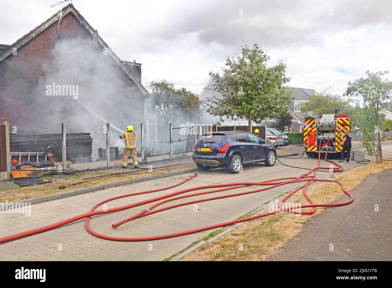 Firefighter bringing house fire blaze under control water hoses on ...