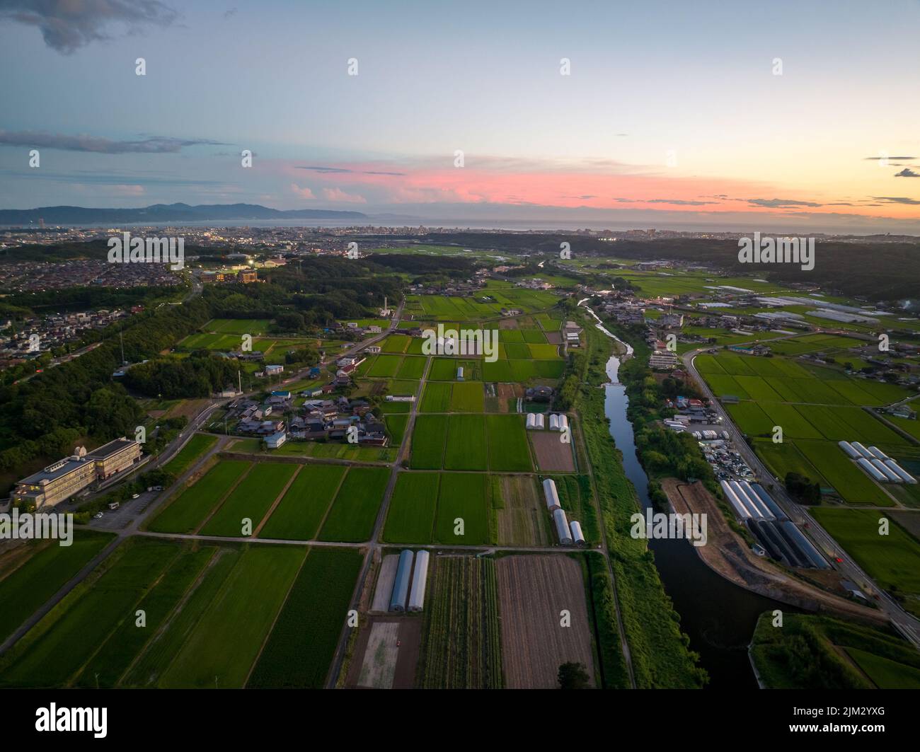 Aerial view of small river through rice fields at sunset Stock Photo ...