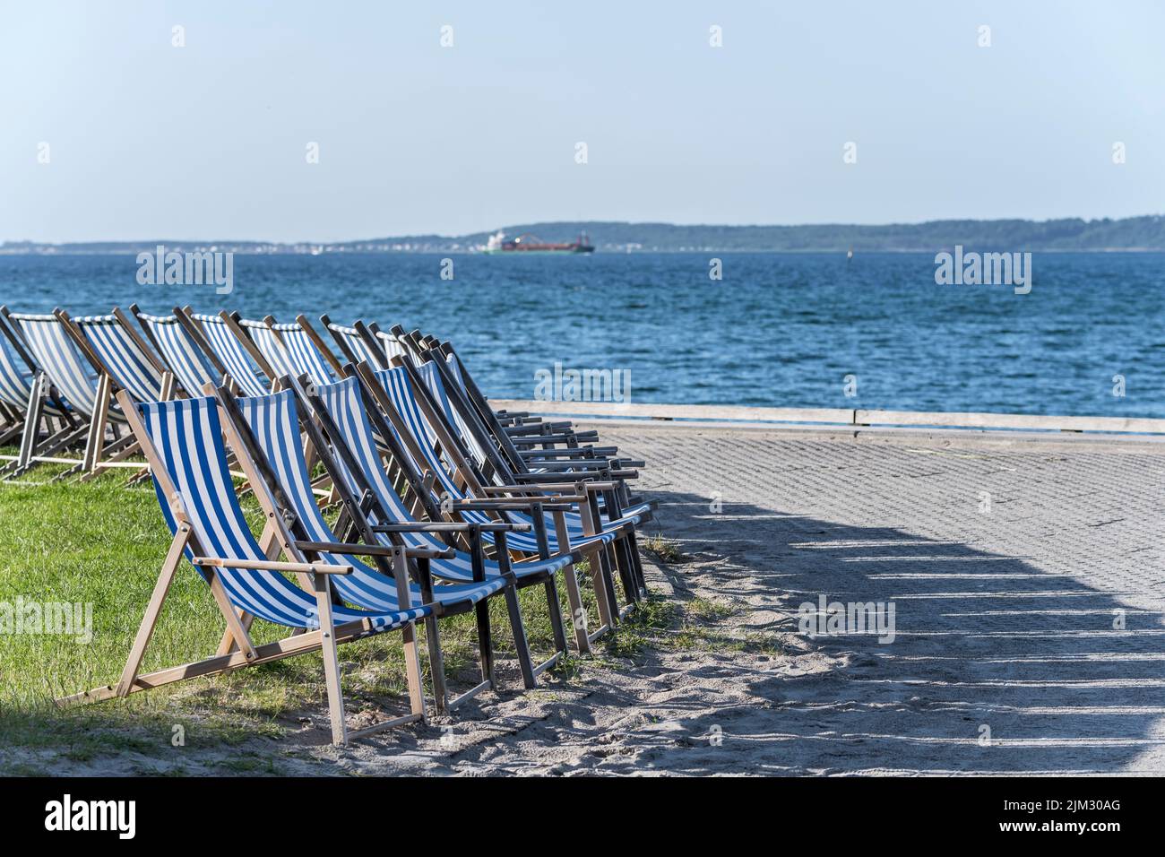 circle of deck chairs on shore facing waters of Oresund sea, shot in ...