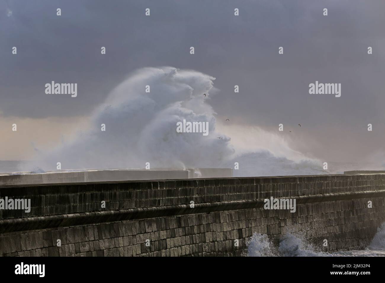 Big wave splash over pier against a dark sky at dusk Stock Photo - Alamy