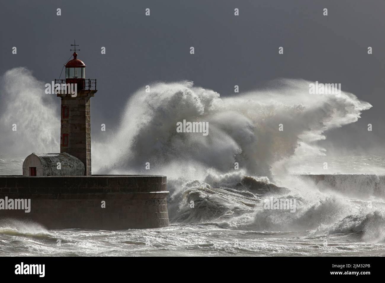 Huge stormy wave splash. Douro river mouth old lighthouse and granite ...