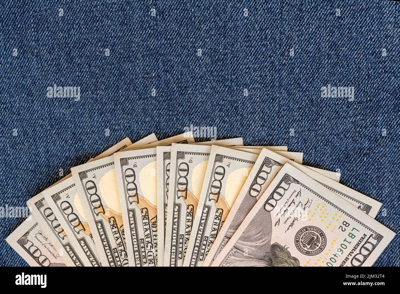 A stack of money on a background of denim Stock Photo - Alamy