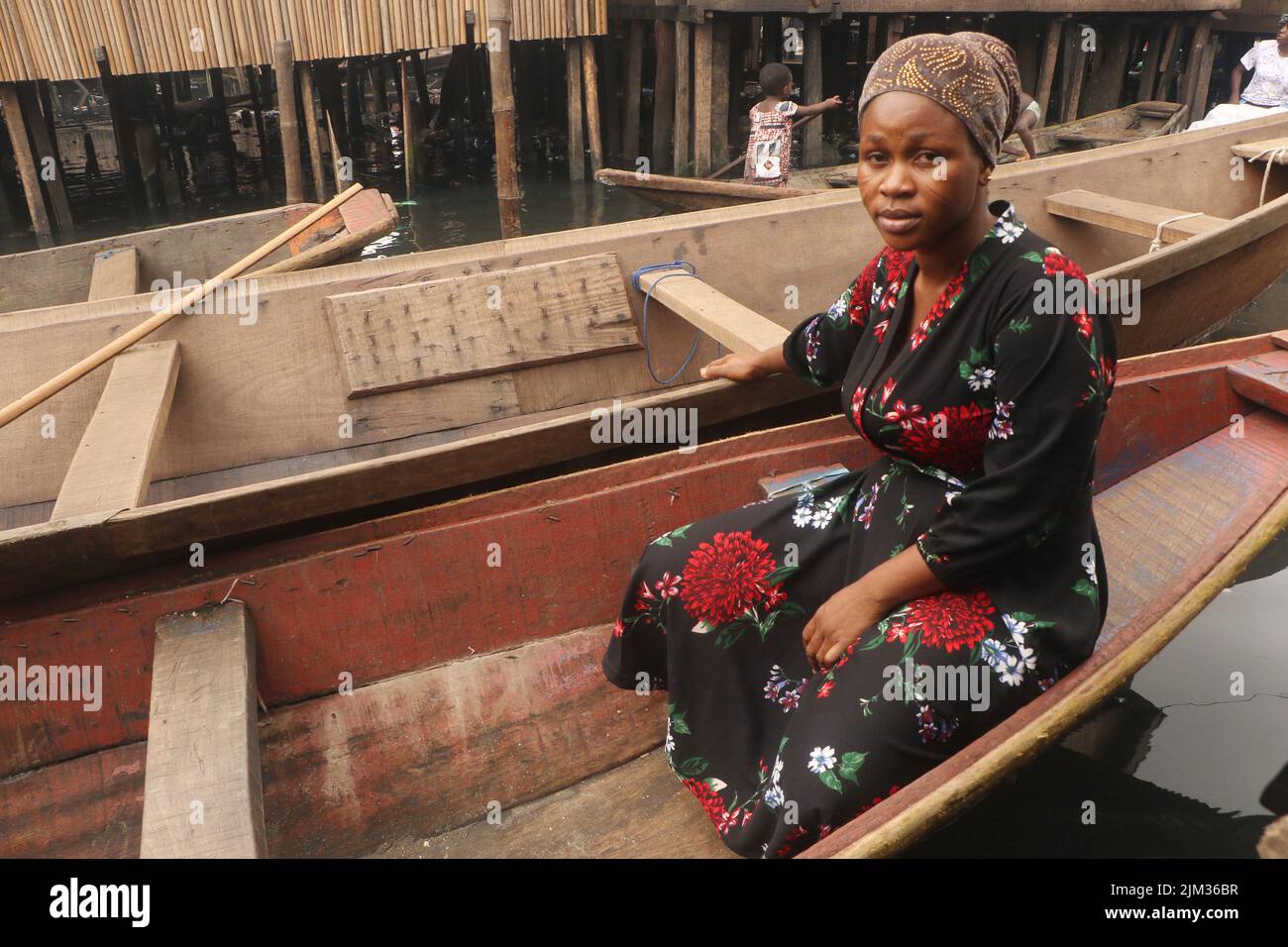 A woman sits in a canoe as she sells food to makoko residents at the ...