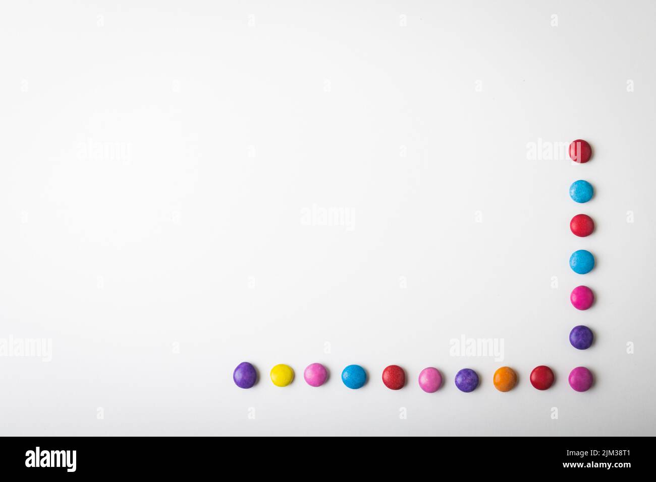 Overhead view of multi colored chocolate candies arranged by copy space ...