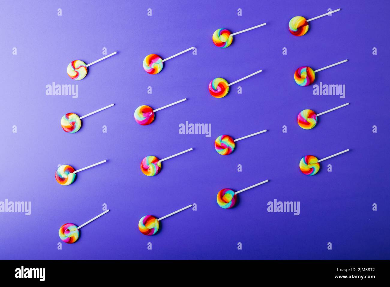 Overhead view of colorful lollipop candies arranged side by side on ...