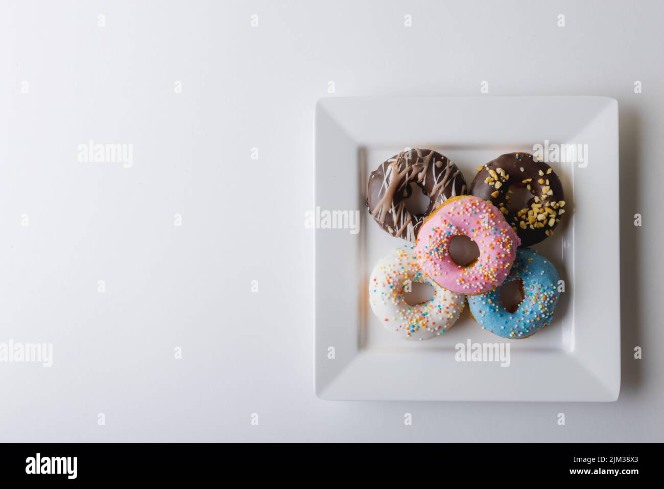 Directly above view of fresh multi colored donuts in square plate by ...