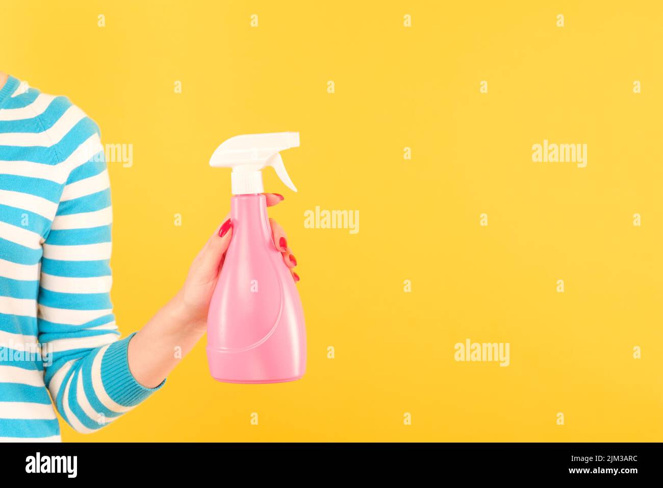 woman hold pink spray bottle yellow home cleaning Stock Photo - Alamy