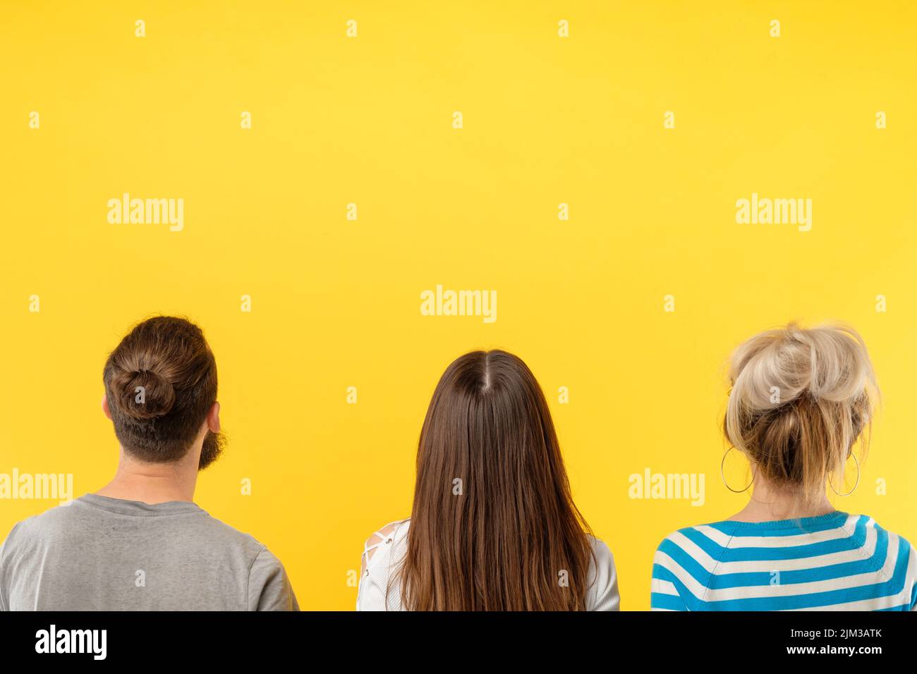 Back view people standing yellow background Stock Photo - Alamy