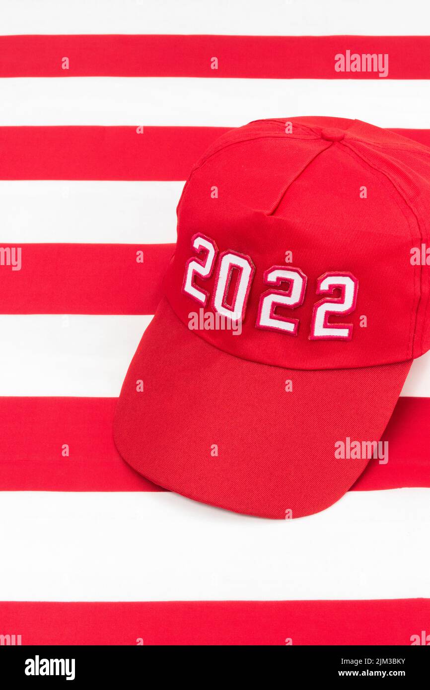 Red MAGA-type hat with 2022 date on US Stars and Stripes flag. For ...