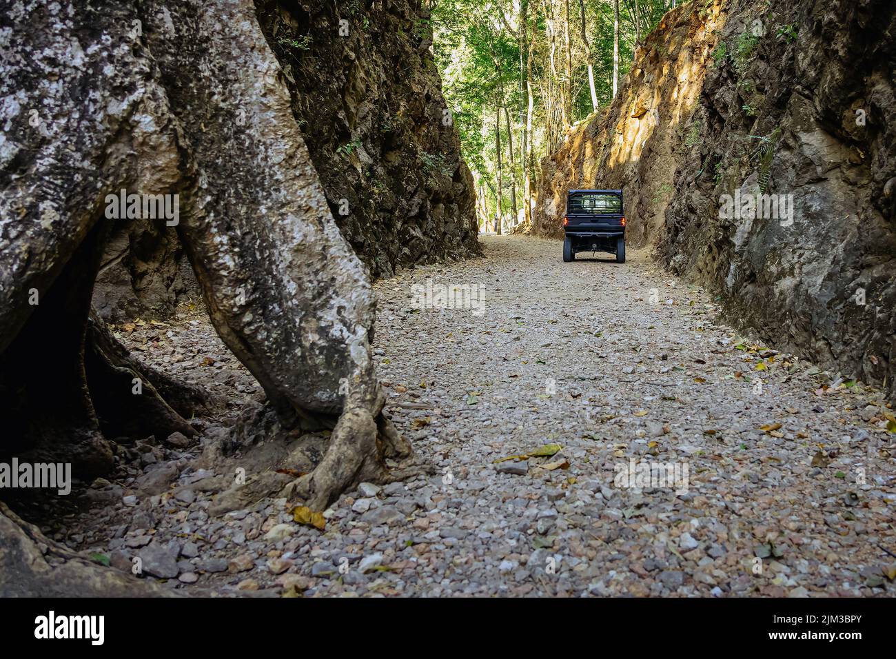Tourist SUV car cruising along a rugged route through the gorge that ...