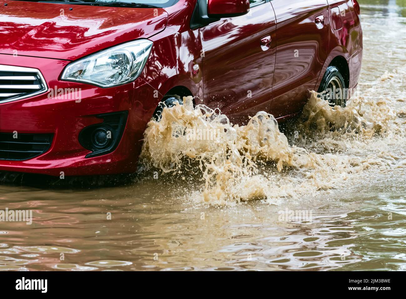 Car passing through a flooded road. Driving car on flooded road during ...