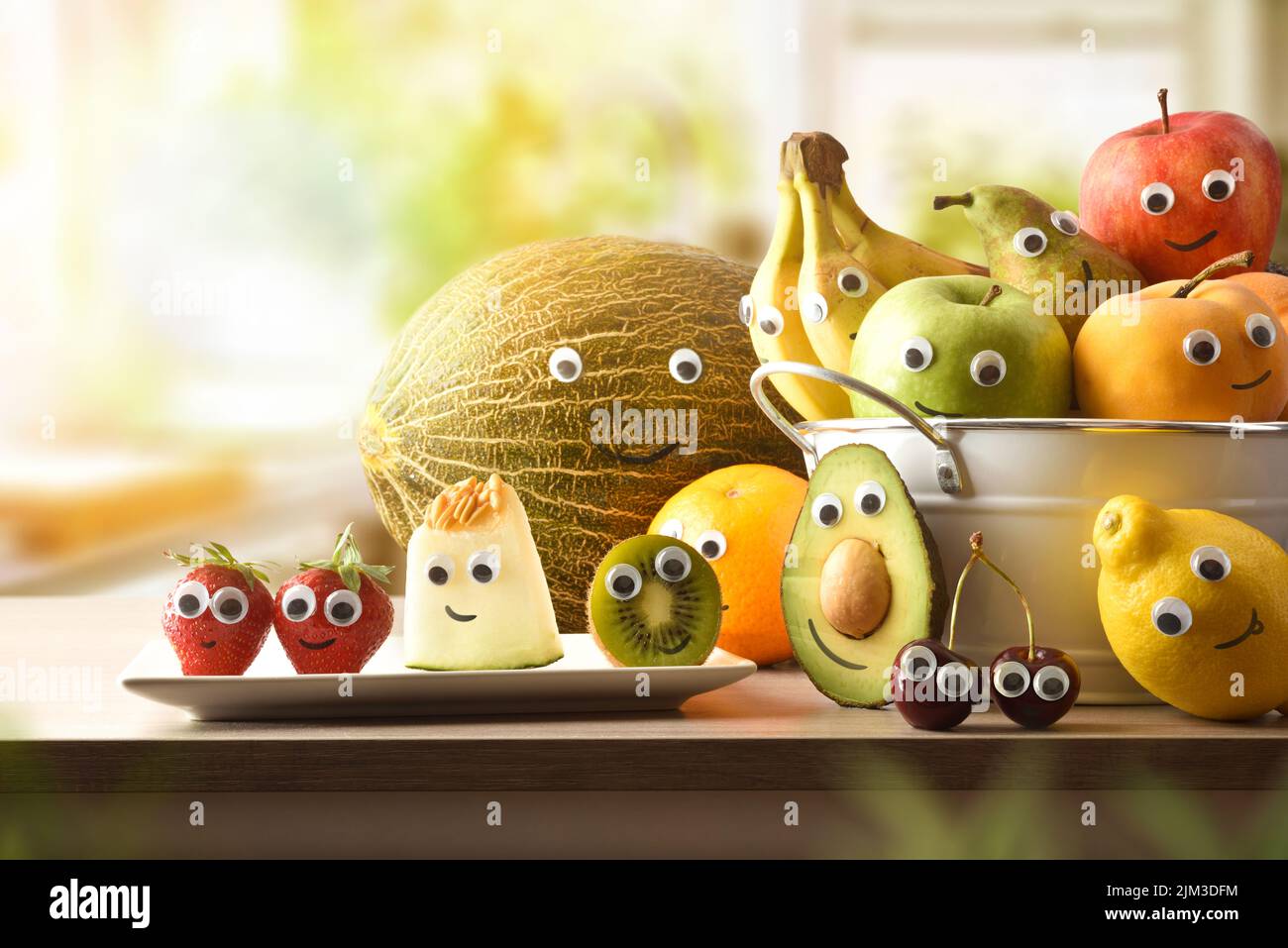 Group of fruits with eyes and mouths in containers on the bench in a ...