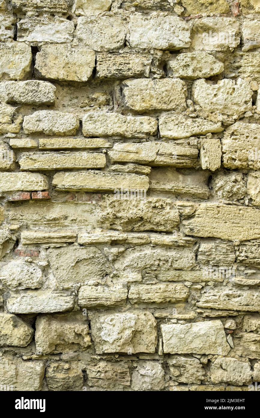 Masonry wall of old stone blocks of limestone. Background texture of ...