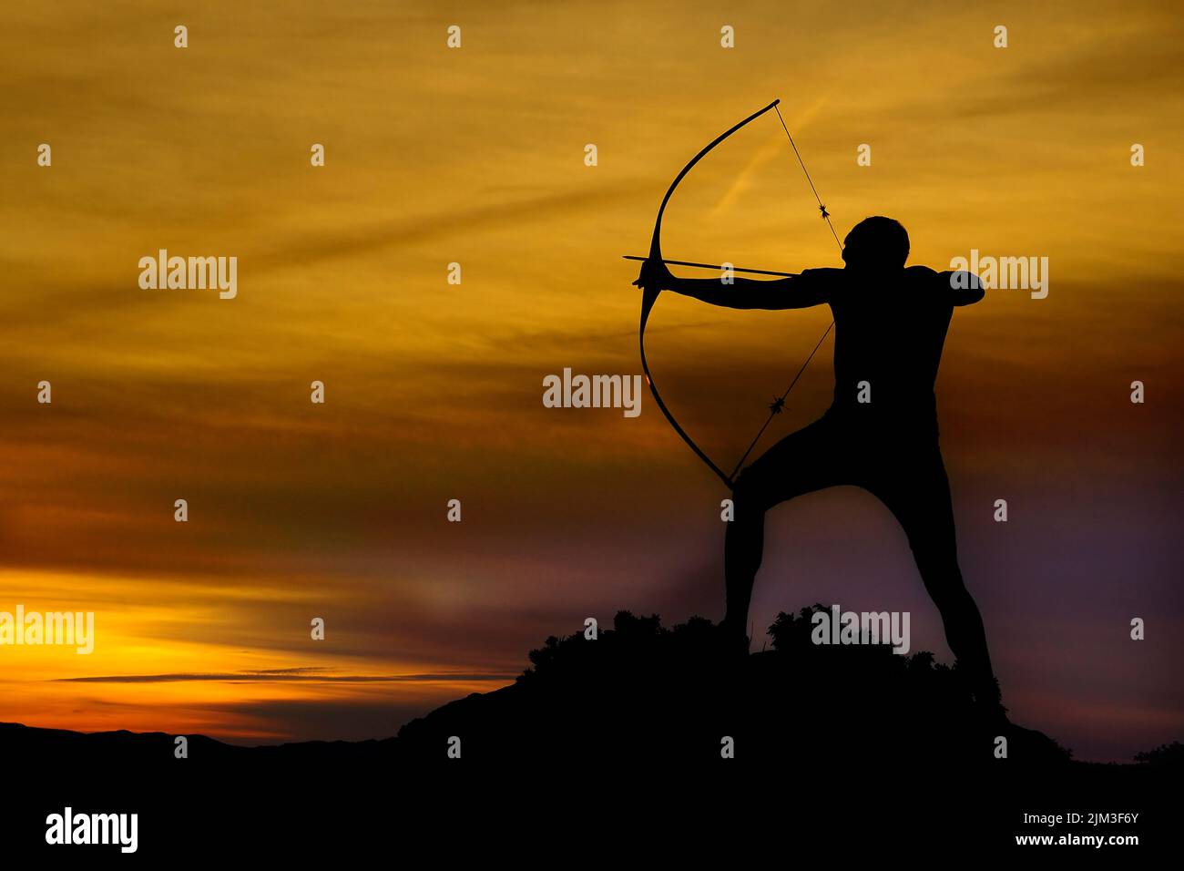 Silhouette of a handsome man with an ancient weapon bow and arrow on a ...