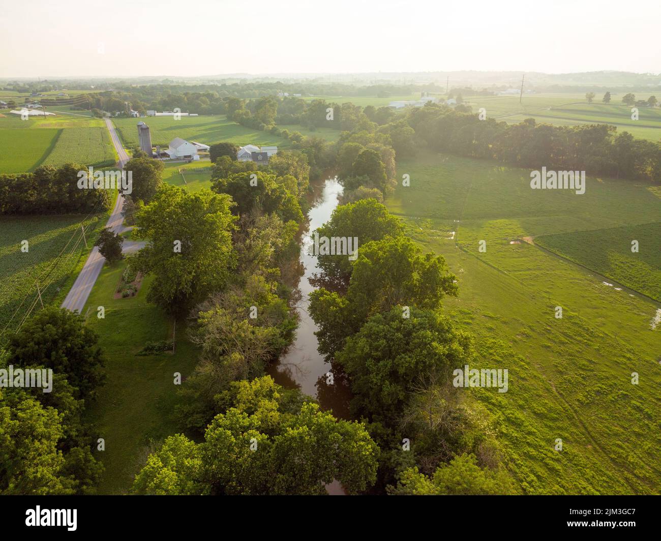 An aerial view of the evening light over the rural farmland in the ...