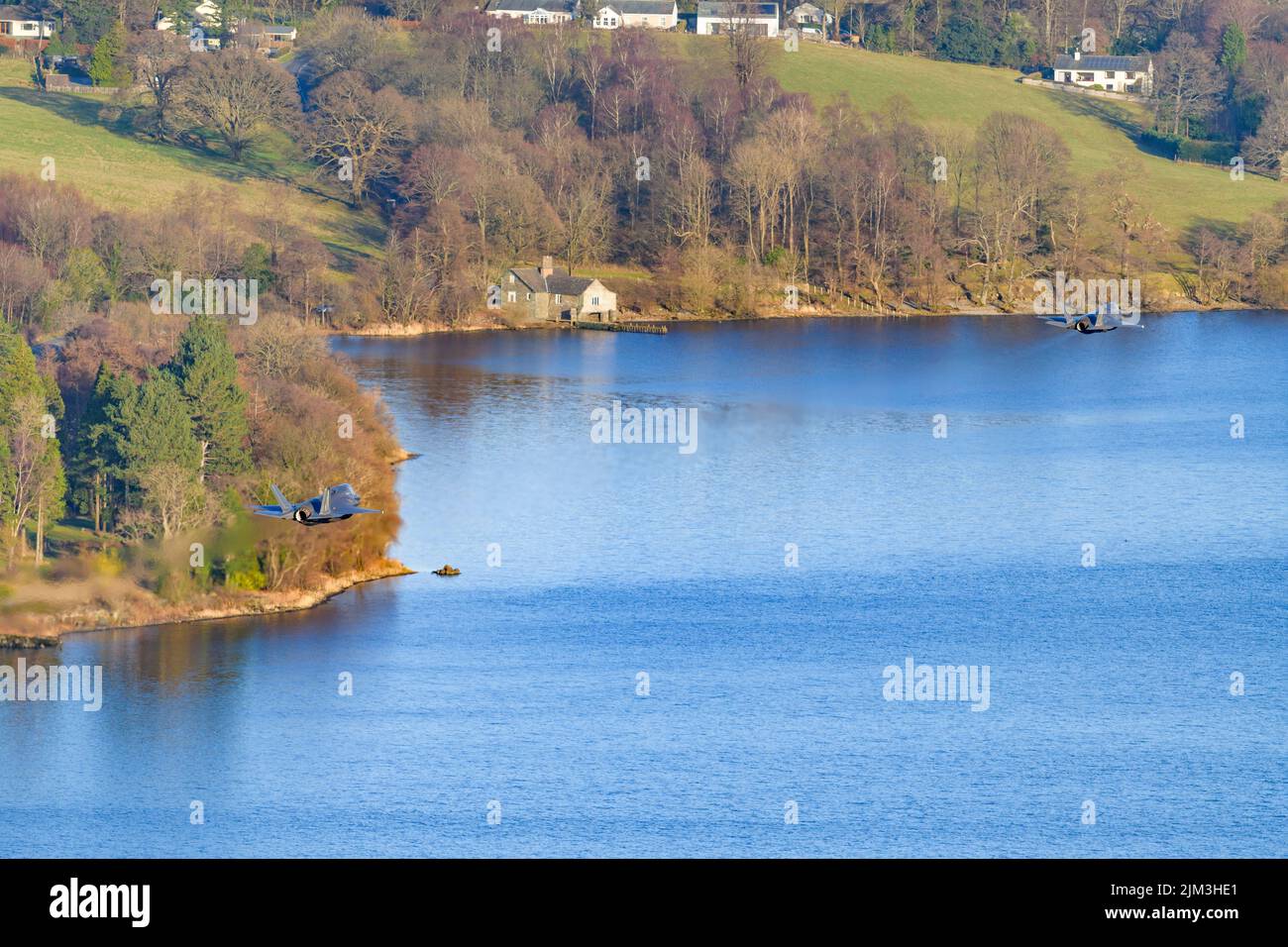 A high angle shot of a lake surrounded by hills covered with autumn ...