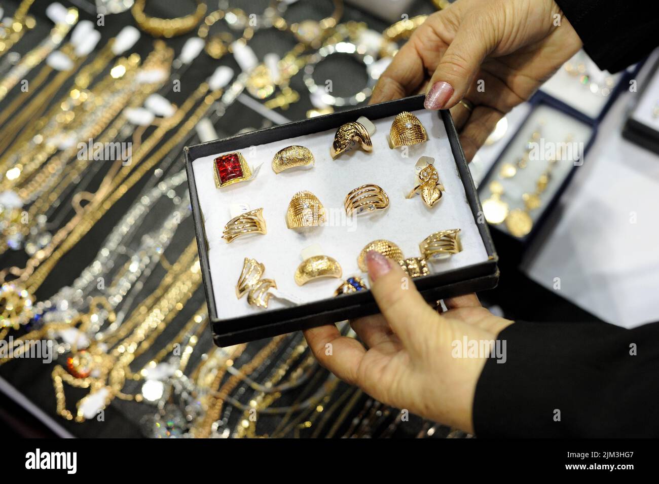 A top view of a person's hands holding a box of golden rings on a ...
