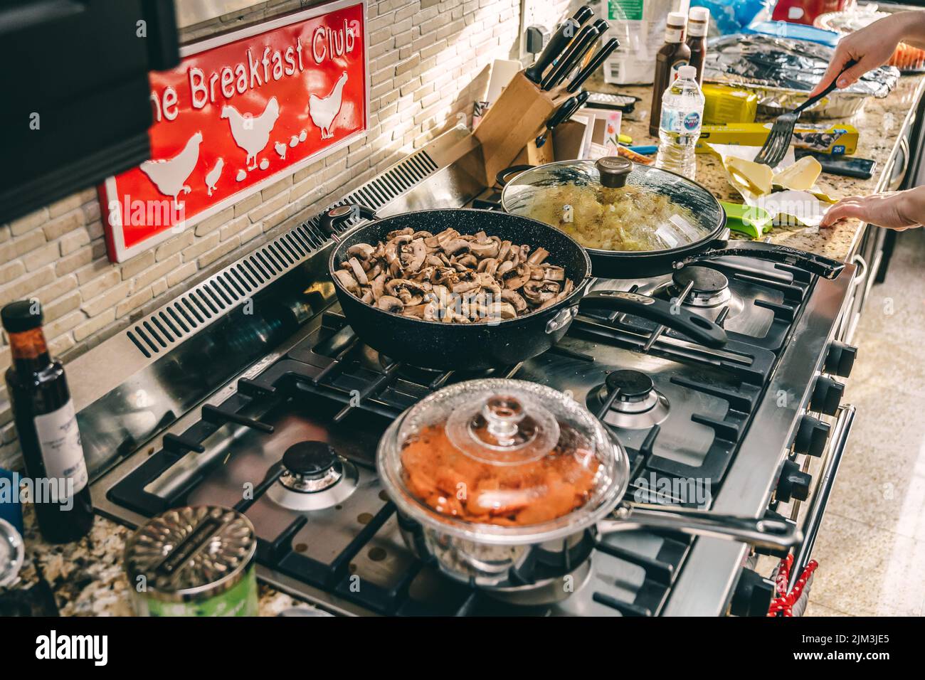 A stove with different dishes on it in a messy kitchen Stock Photo - Alamy