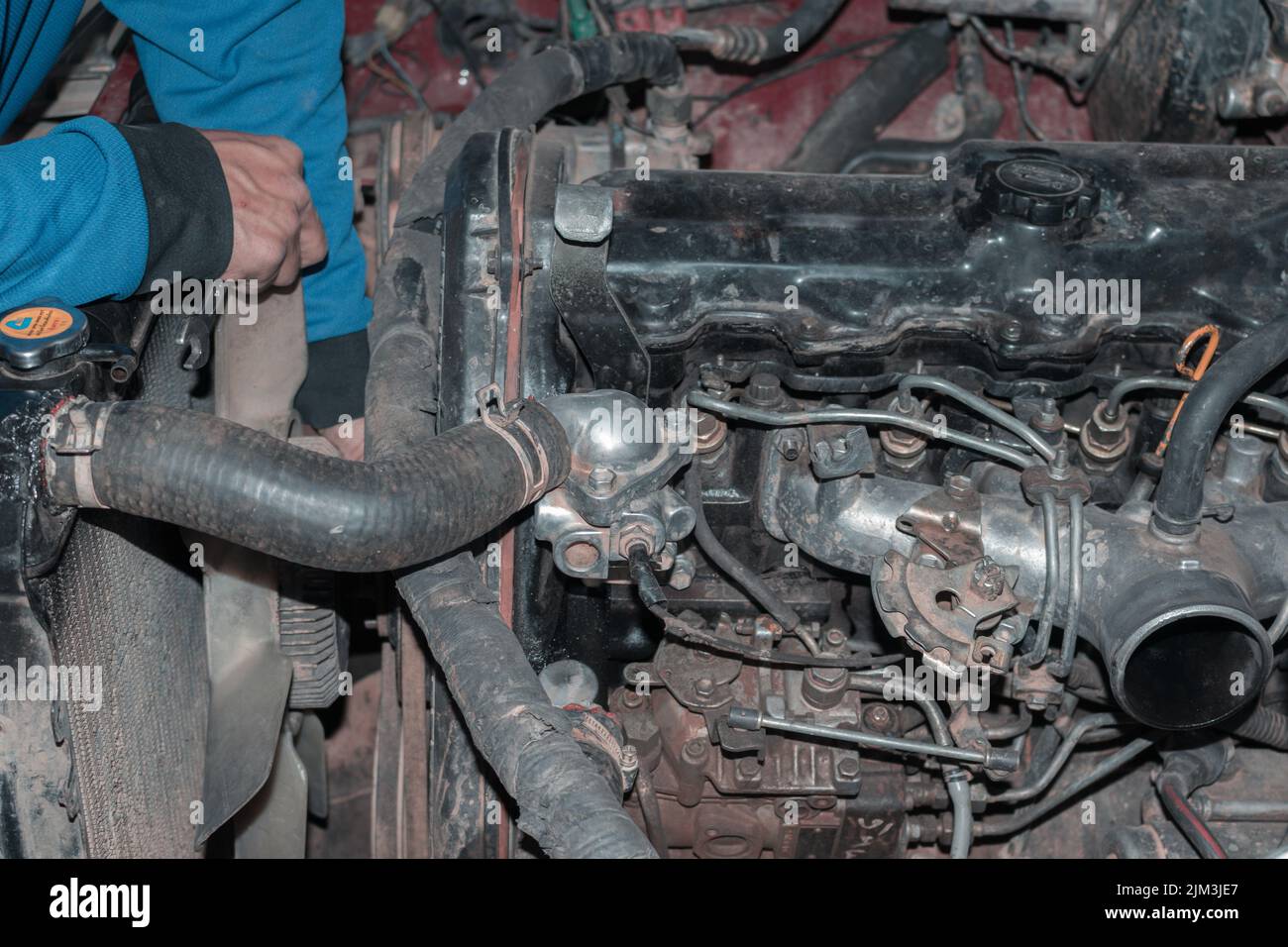 The mechanic is checking the engine. The mechanic is checking the ...