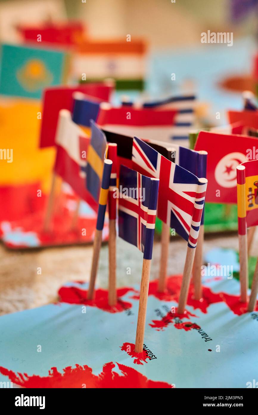 A vertical shot of small colorful paper flags on wooden stickes pinned ...