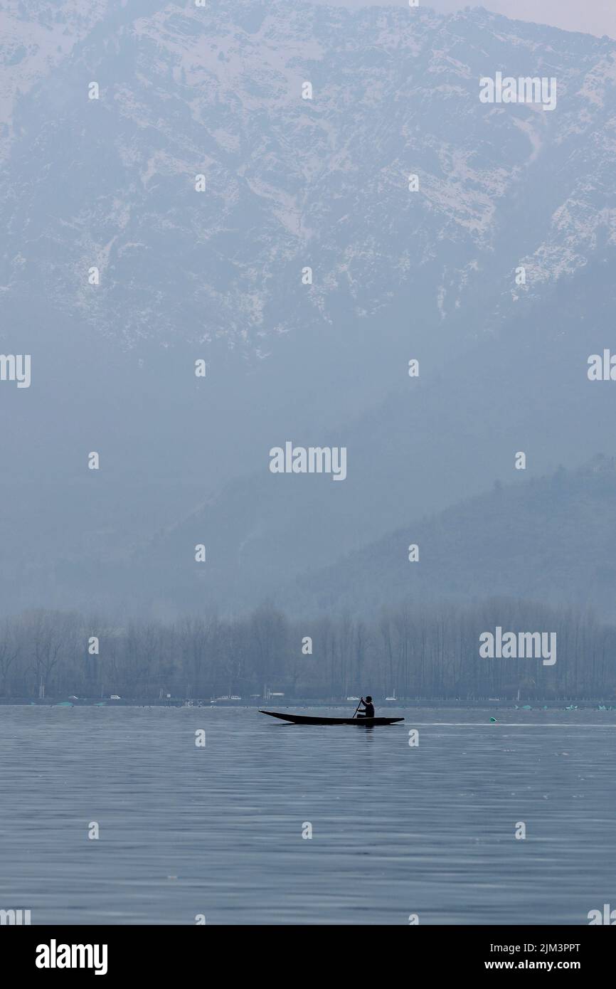 A silhouette of a Kashmiri Shikara boat sailor Indian man on Dal Lake ...