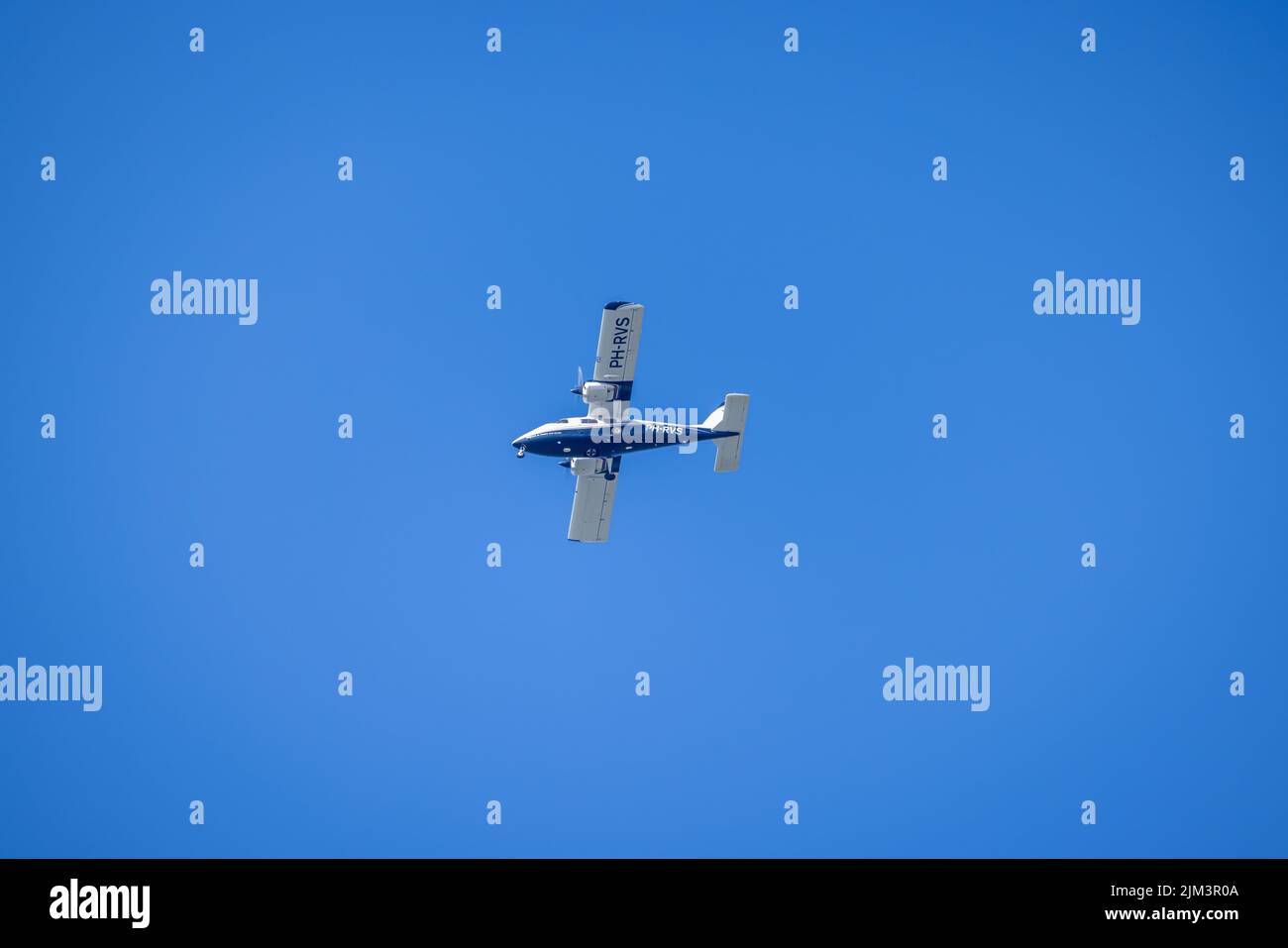 an Aerial survey Plane in a clear blue sky with a camera looking down ...
