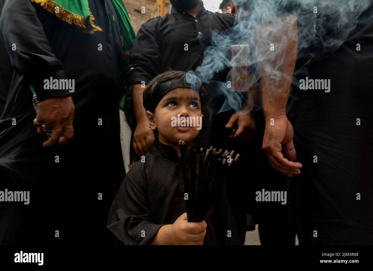 A Kashmiri Shia Muslim boy holds incense sticks during a religious ...