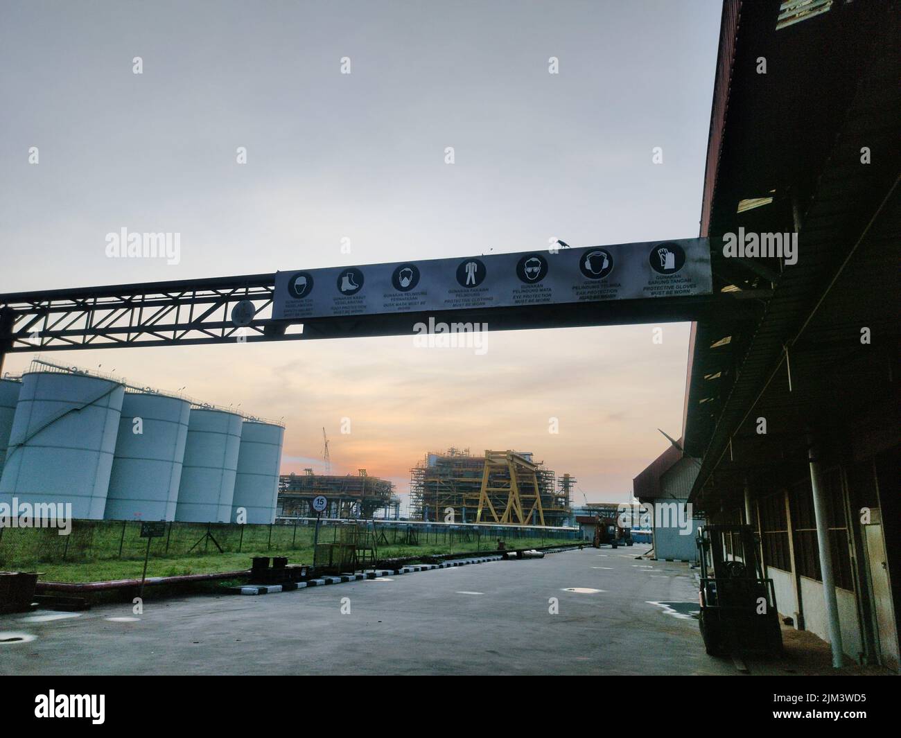 A beautiful shot of PPE sign board with a cooking oil tank farm and oil ...