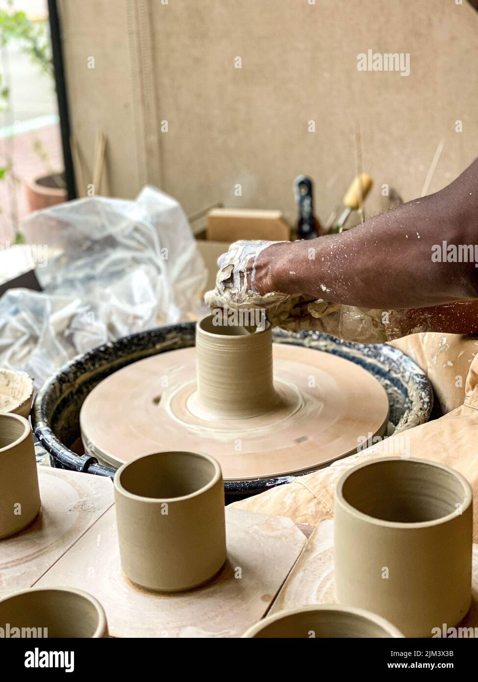 A man throwing a clay mug on a potters wheel Stock Photo - Alamy