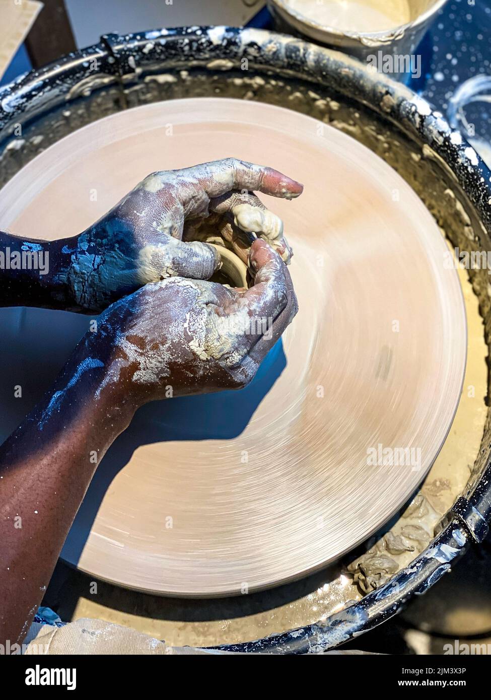 A man throwing a clay mug on a potters wheel Stock Photo - Alamy