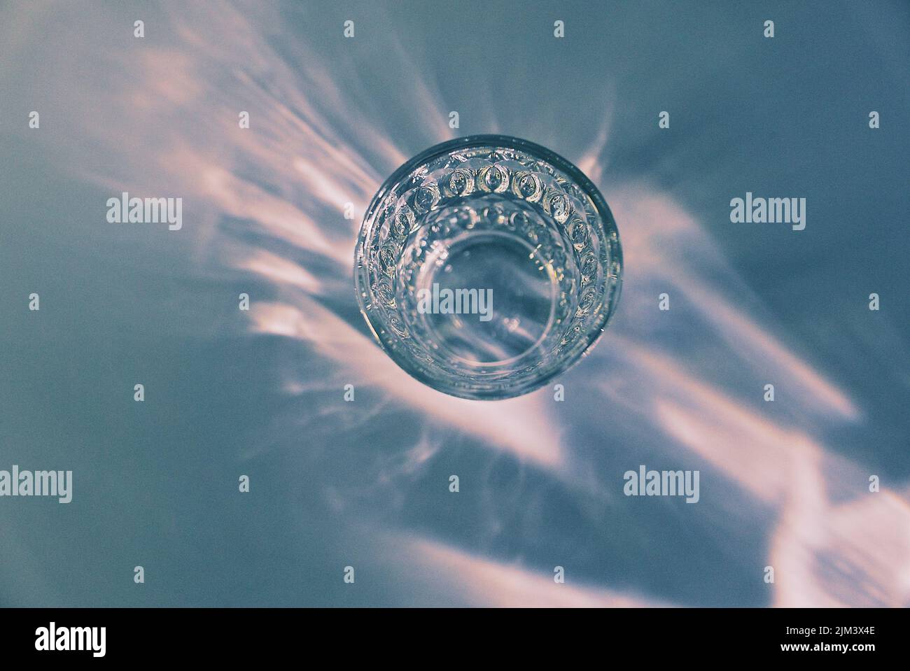 A top view of glass with shadow in blue background Stock Photo - Alamy