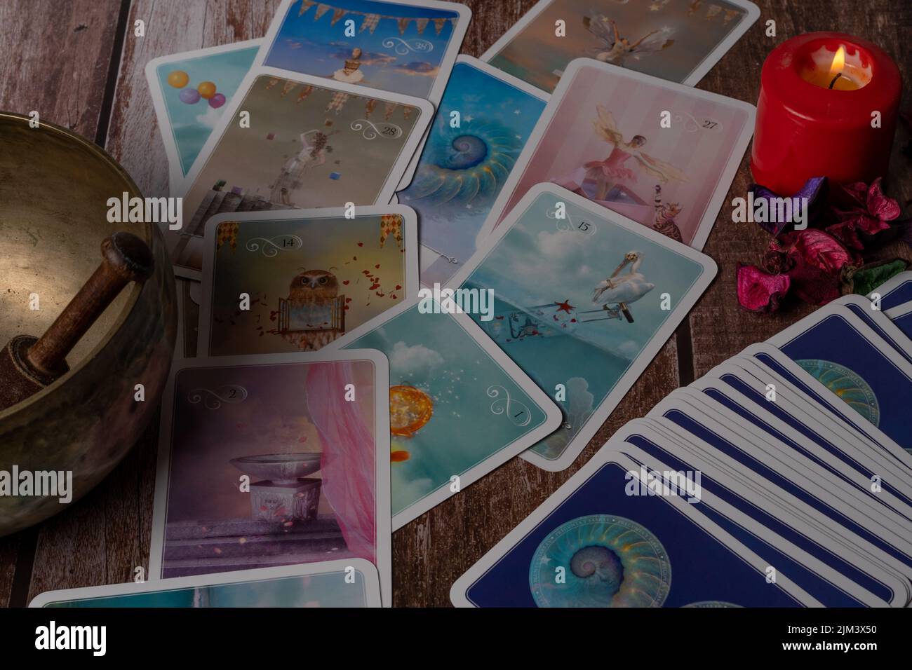 colorful tarot cards "oracle" lighted red candle and Tibetan bowl on a ...