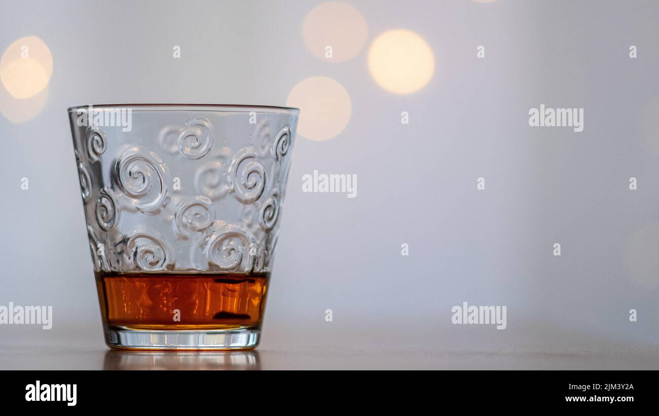 A glass of whiskey on a table with bokeh lights in the background Stock ...