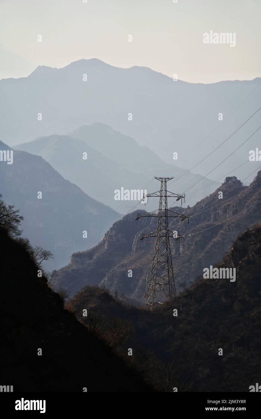 A vertical view of a transmission power line in the middle of steep ...