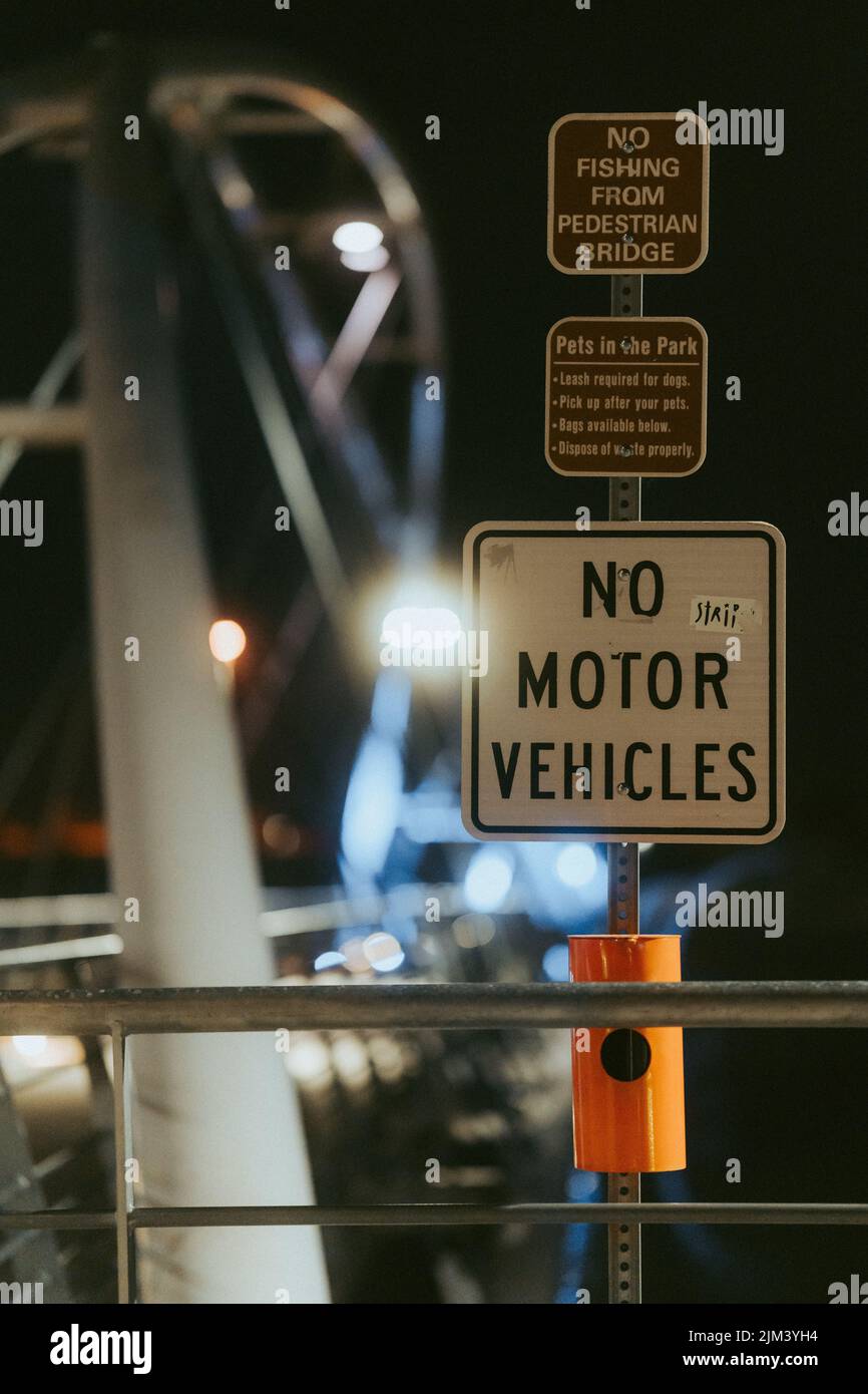 Vertical shot of three instruction and warning signs lined vertically ...