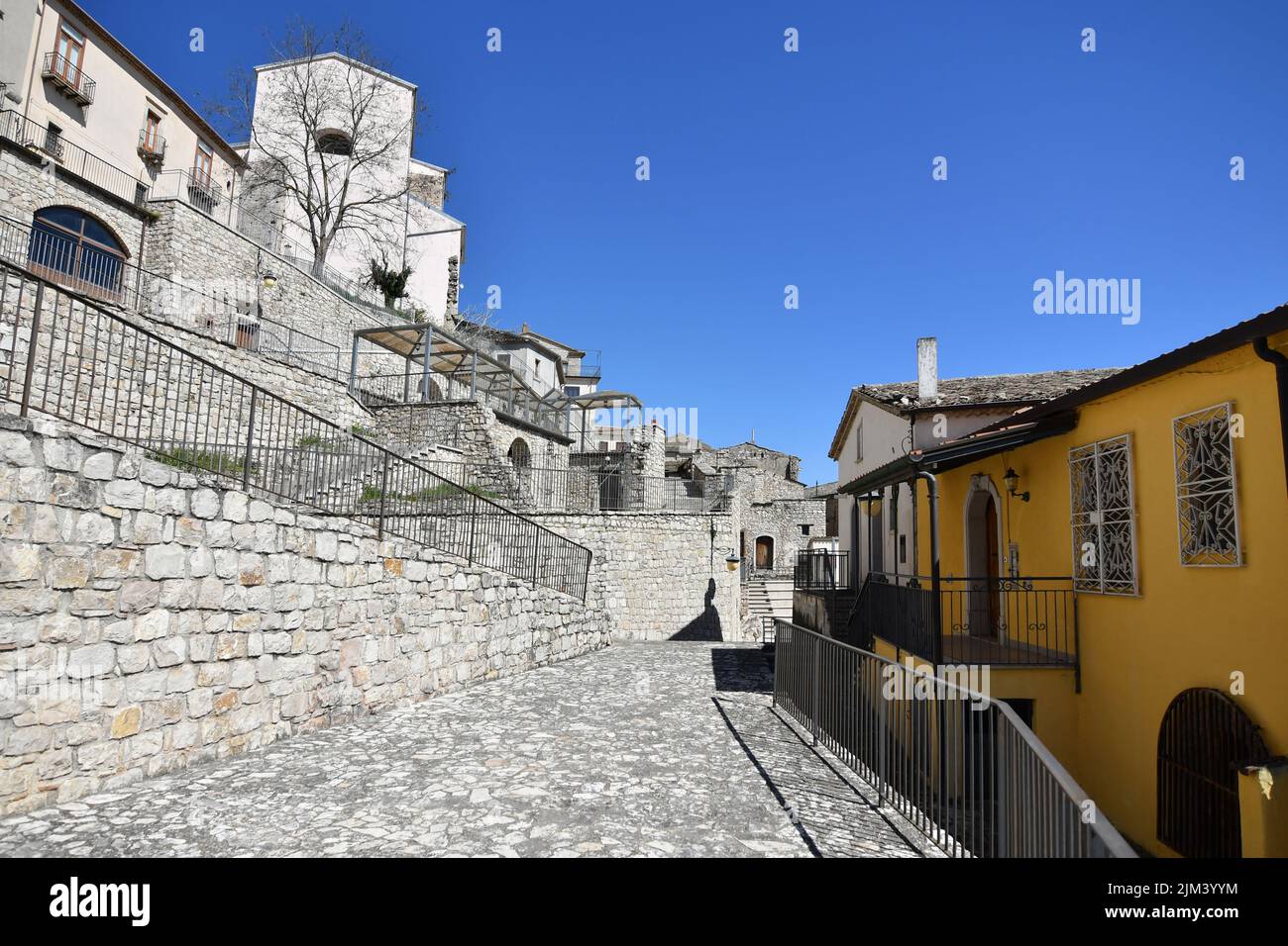 A Narrow brick street with houses under a blue sky in a small village ...