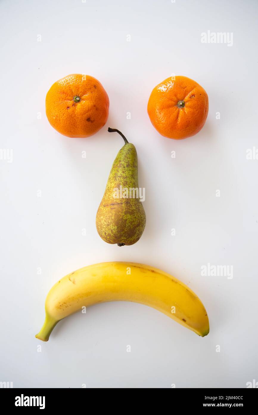 A vertical closeup of various fruits isolated on white background. A ...