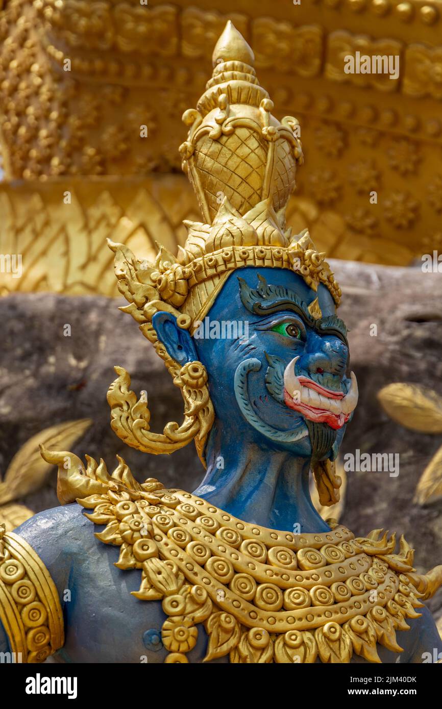 A vertical closeup of a demon statue in a buddhist temple in Thailand ...