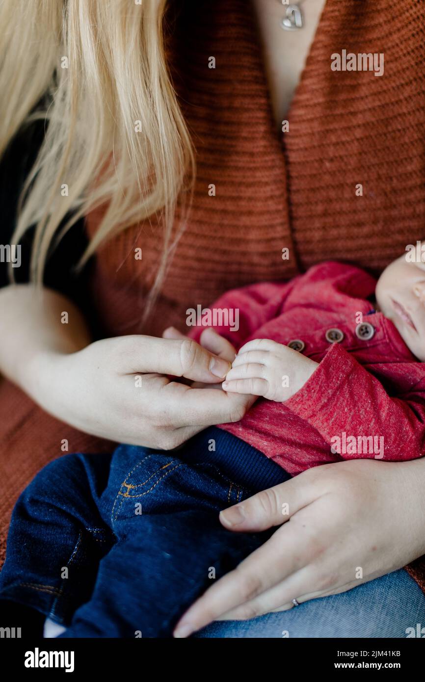 A closeup shot of a newborn baby 1 week old in his mother's arms ...