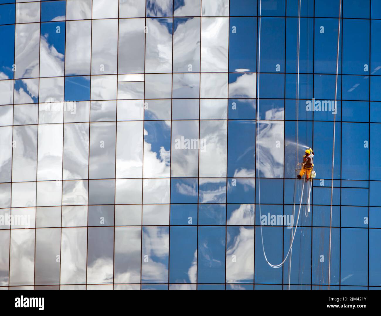 A worker cleaning glass windows of modern building Stock Photo - Alamy