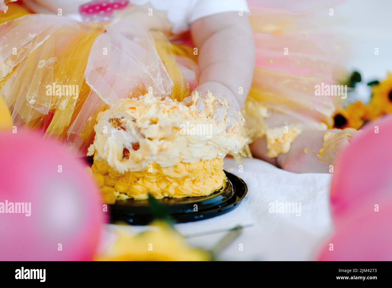 A closeup portrait of a 1 year old baby girl sitting on the table among ...
