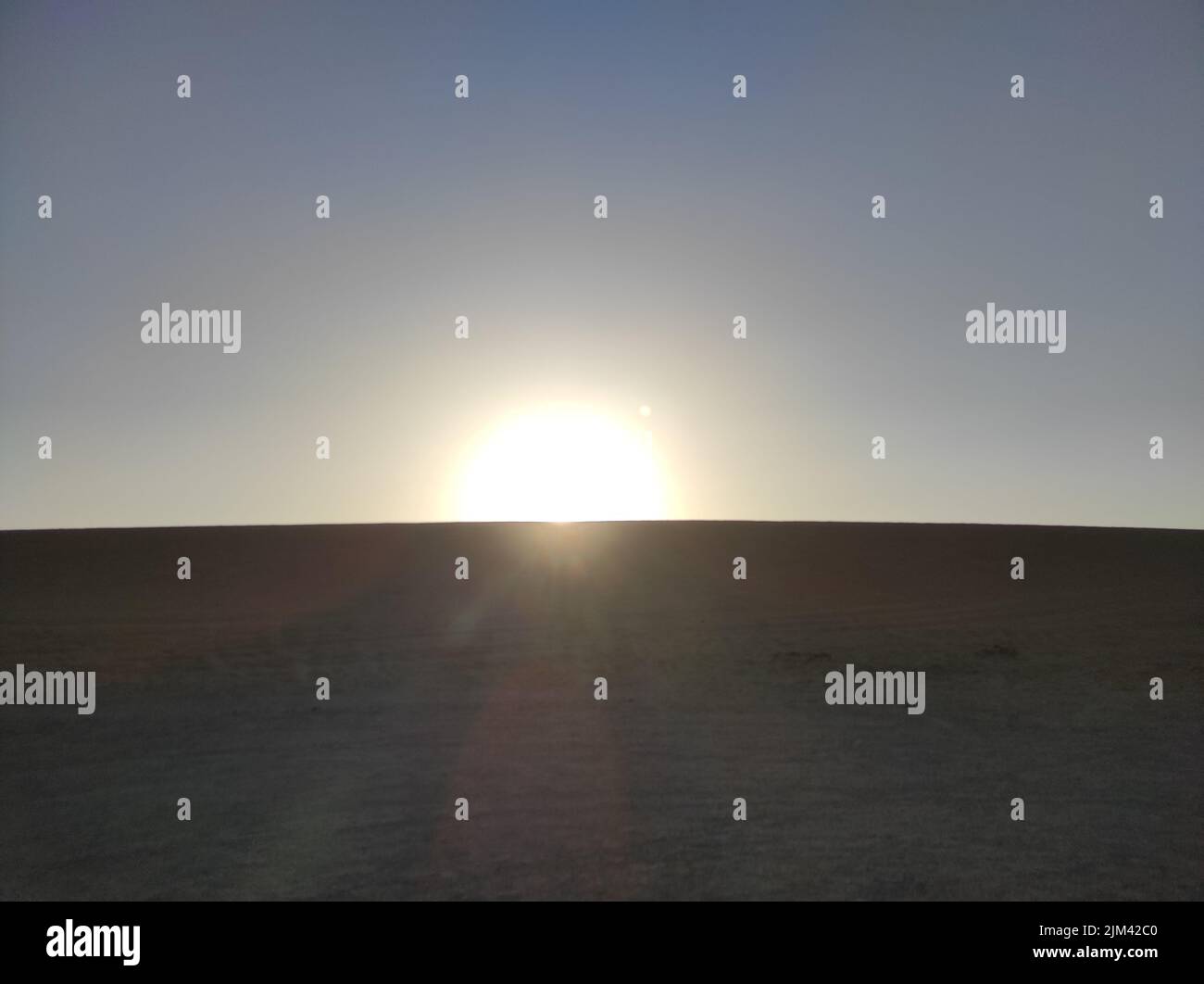 A breathtaking view of the sun rising behind the desert dune Stock ...