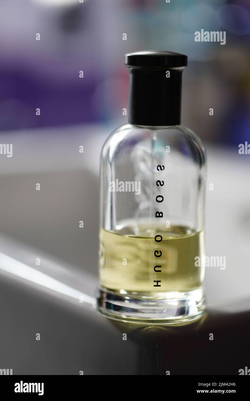 A vertical shot of Hugo Boss perfume bottle for men with a logo and a ...