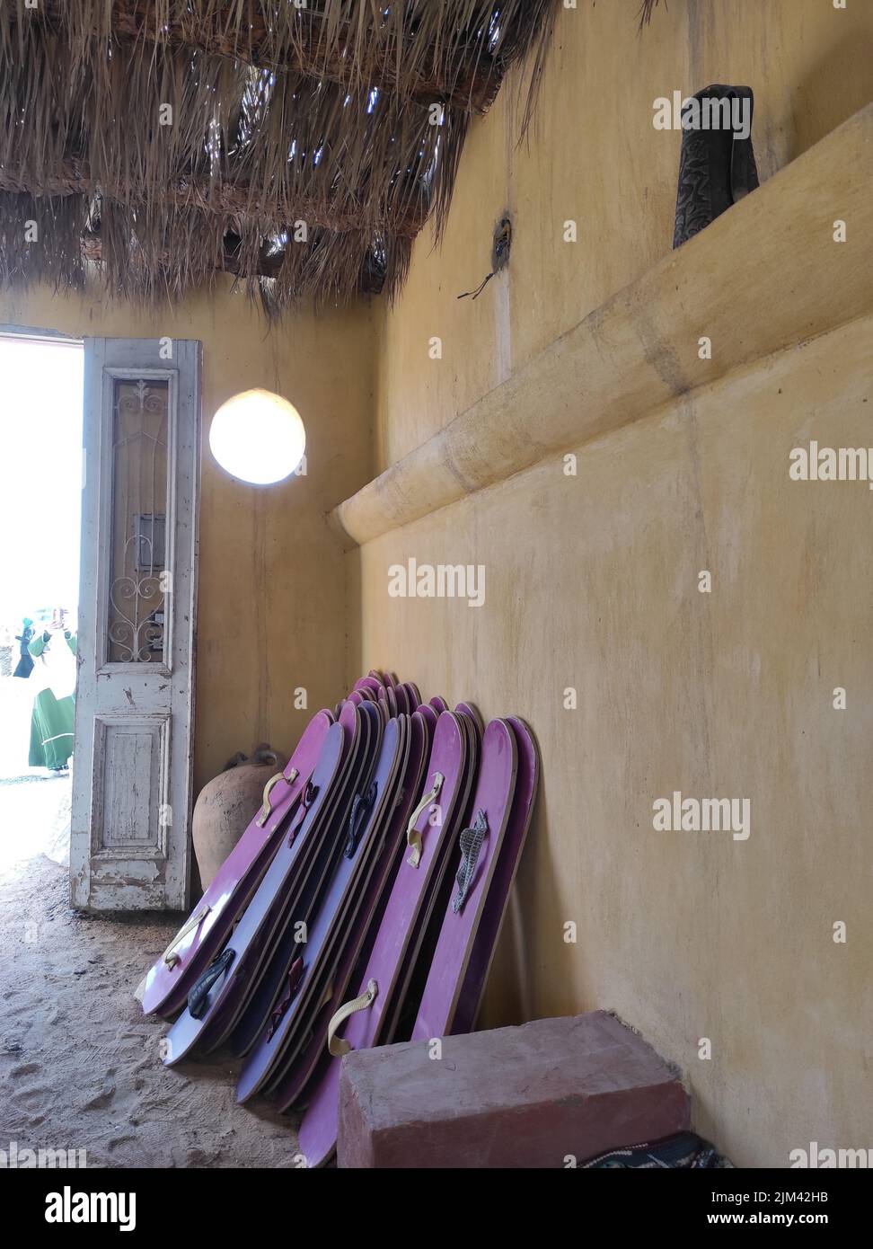 A vertical shot of snowboards leaned on a building wall in a desert ...