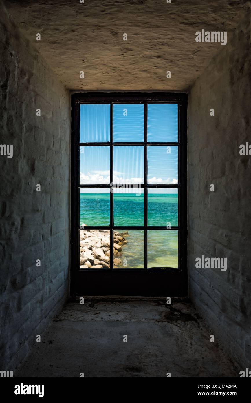 A vertical shot of a window with a view of the Atlantic Ocean off the ...