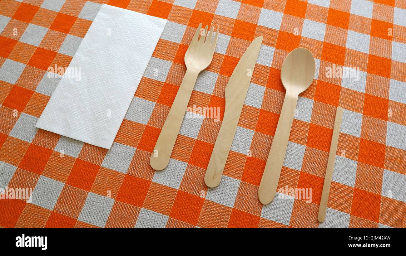 Wooden cutlery, disposable fork, knife and spoon on fabric table cloth ...