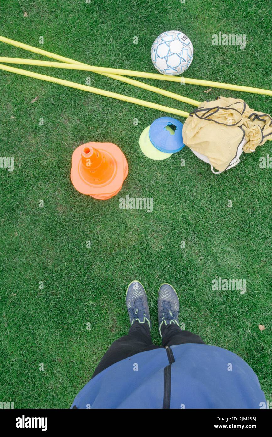 A top view of a person's feet with football game equipment on the grass ...
