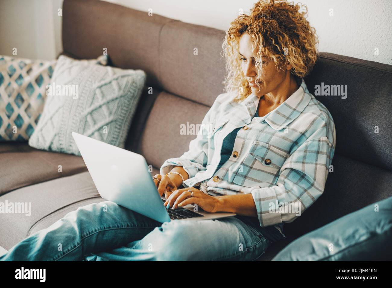 Hipster style woman use laptop at home sitting comfortably on the sofa ...