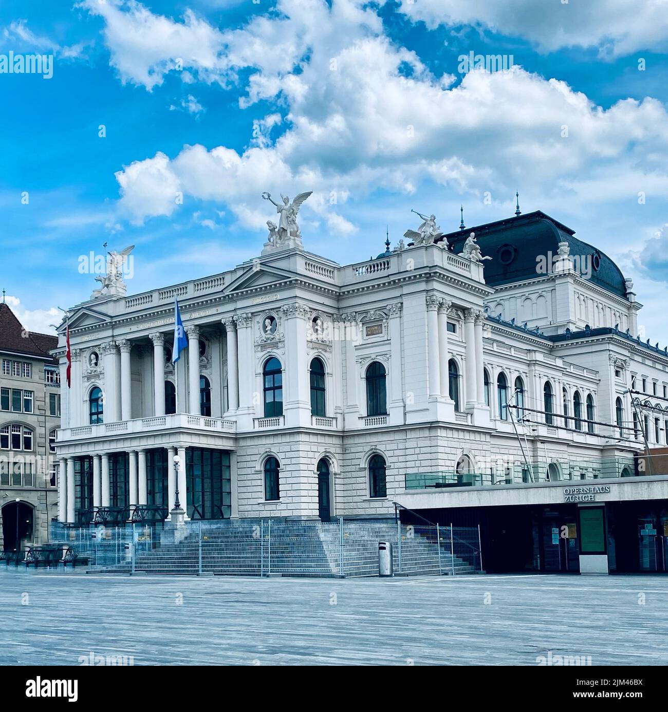 The facade of the famous Zurich Opera House against a blue cloudy sky ...