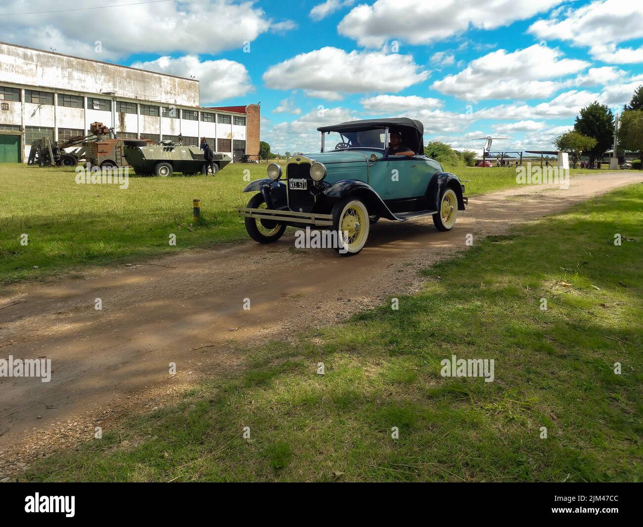 Old cyan Ford Model A coupe roadster circa 1930 traveling on a country ...